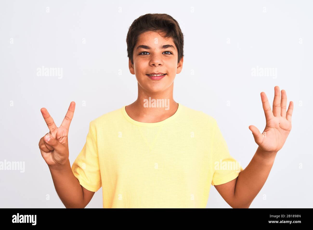 Handsome teenager boy standing over white isolated background showing ...