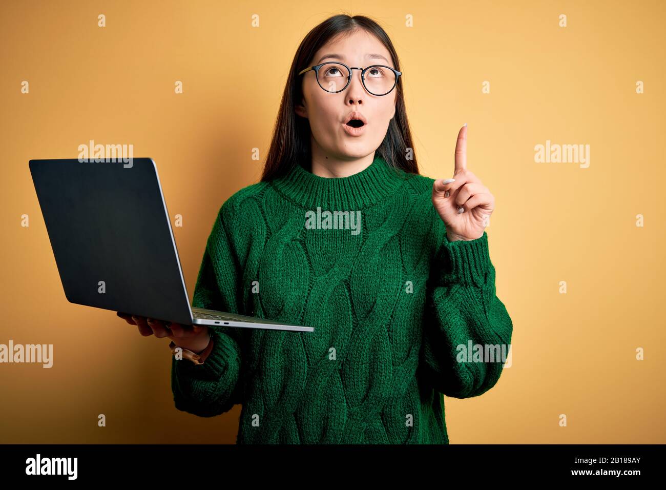 Young asian business woman wearing glasses and working using computer ...