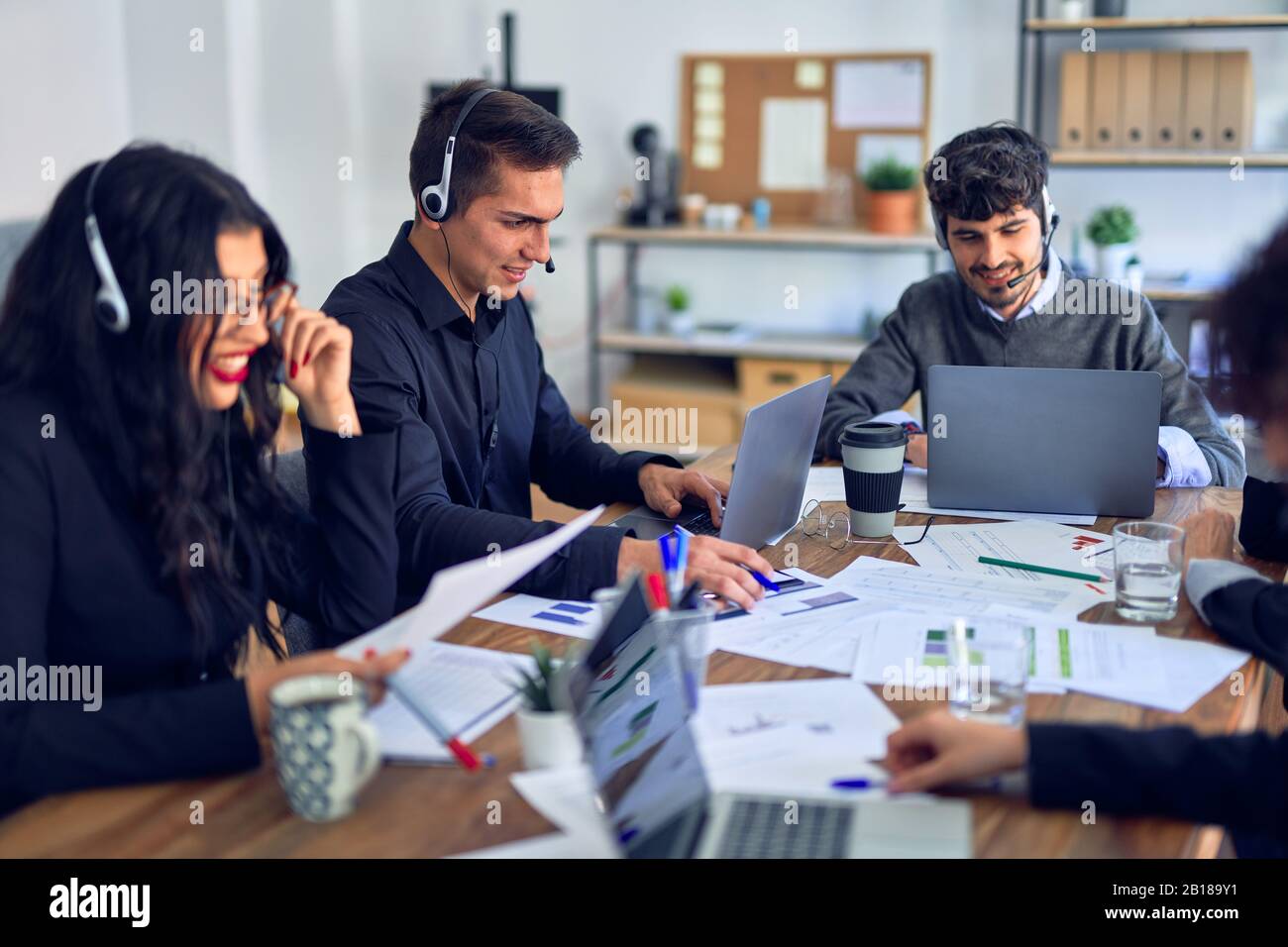 Group of call center workers smiling happy and confident. Working together with smile on face ...
