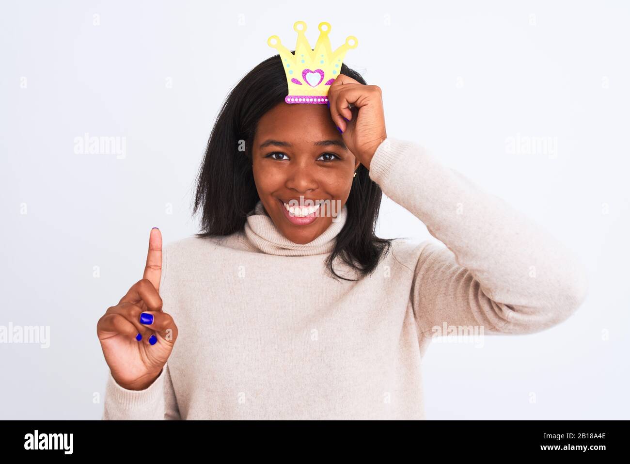 Young african american woman wearing pretend queen crown over isolated ...