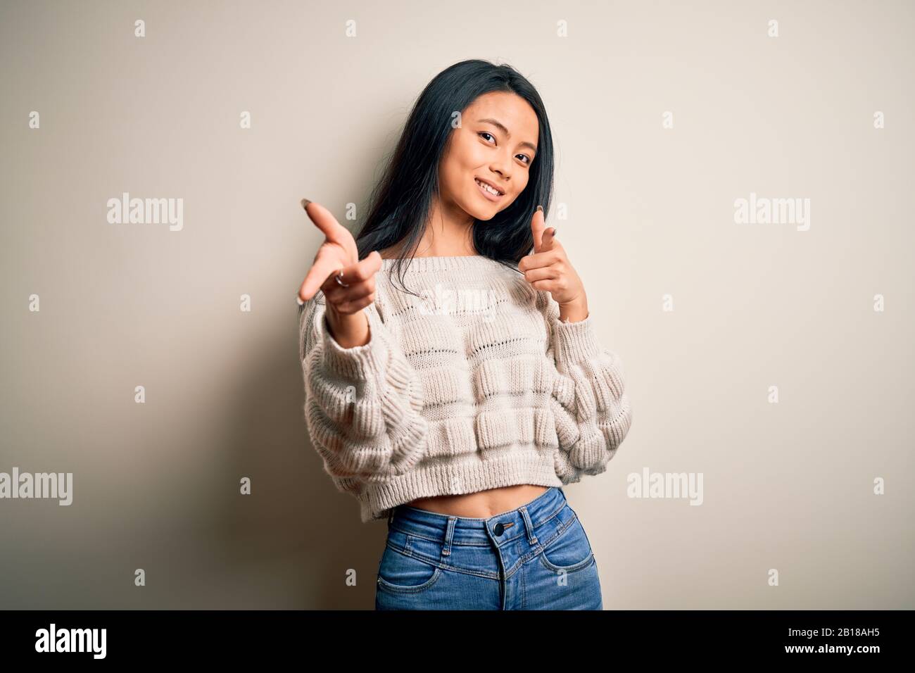 Young beautiful chinese woman wearing casual sweater over isolated ...