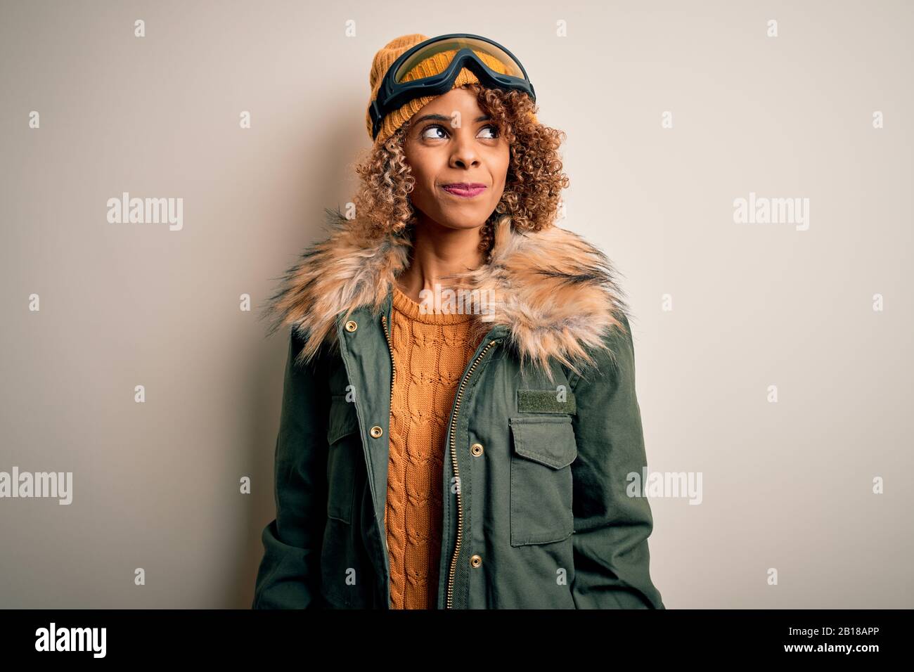 Young african american skier woman with curly hair wearing snow ...