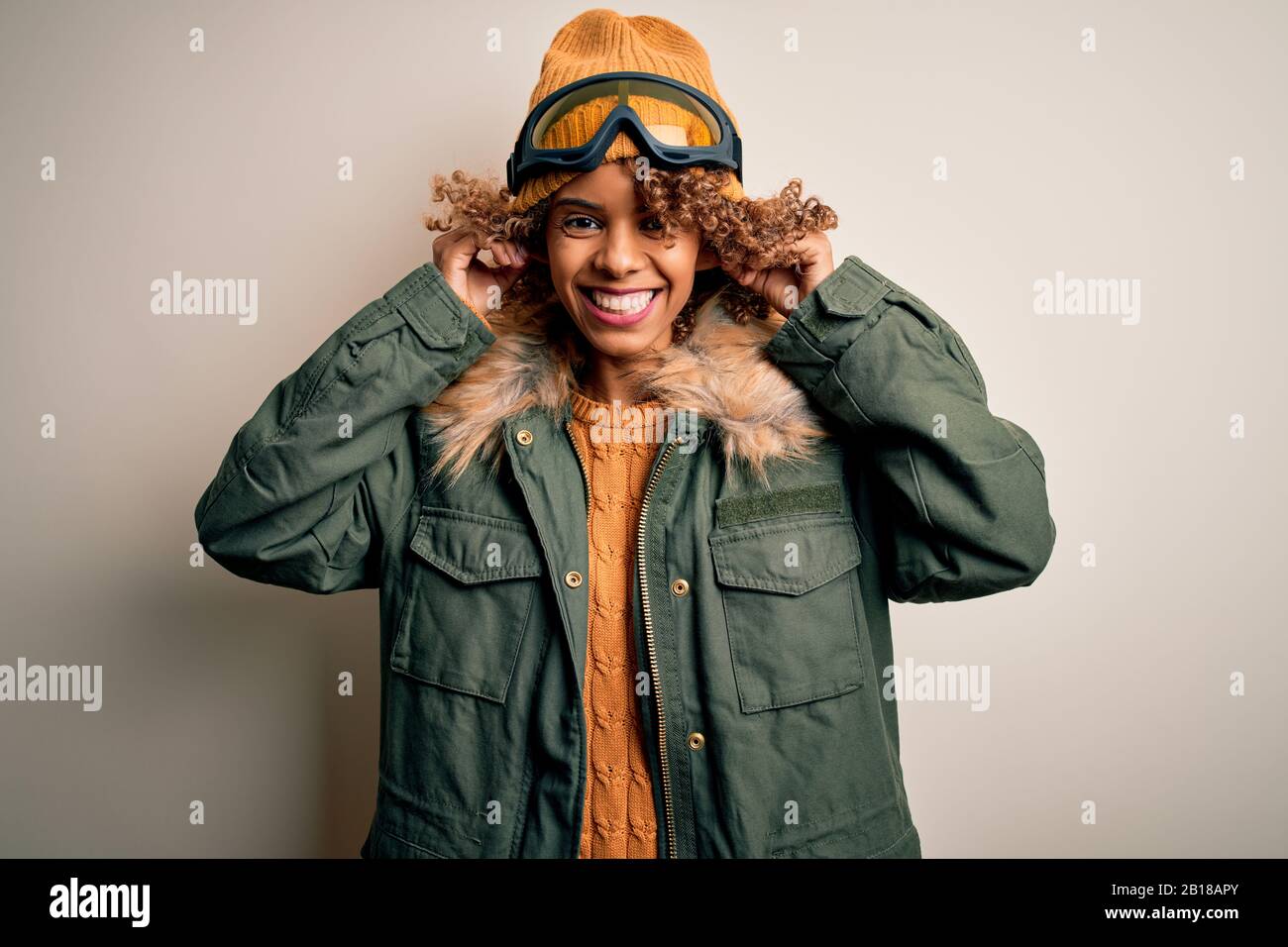 Young african american skier woman with curly hair wearing snow ...