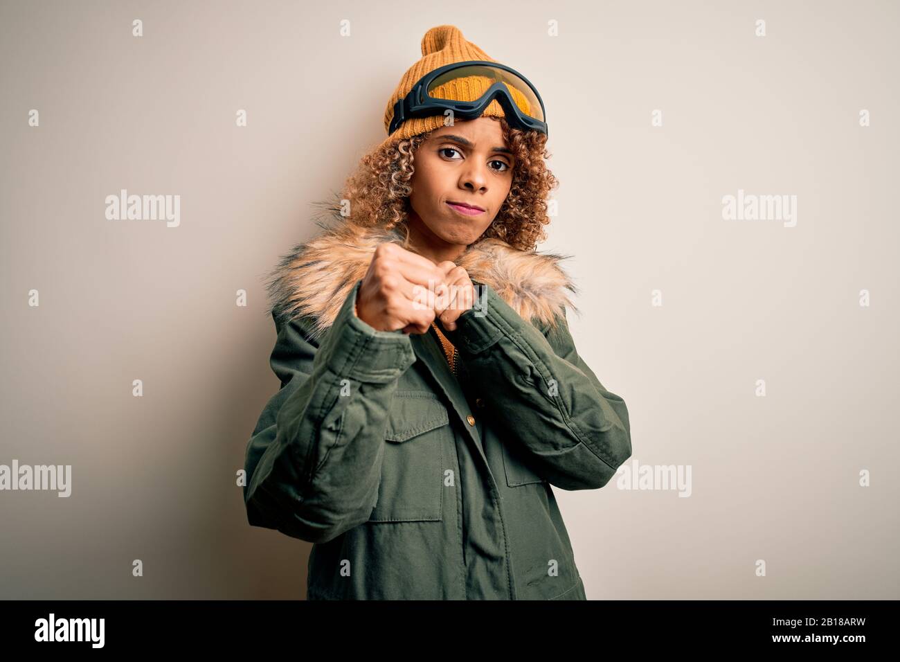 Young african american skier woman with curly hair wearing snow ...