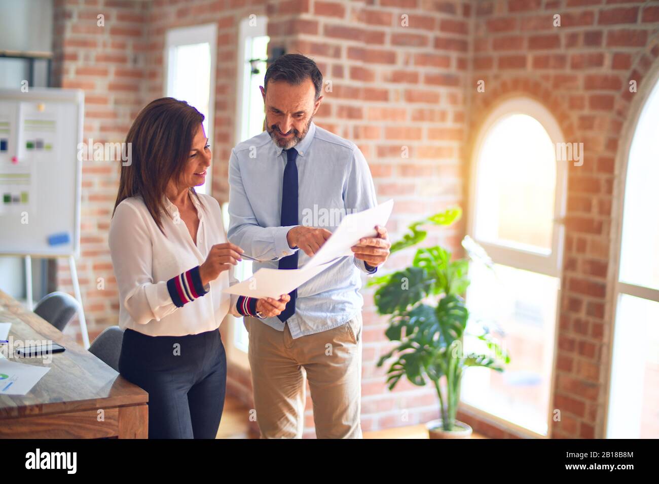 Two middle age business workers smiling happy and confident. Standing ...