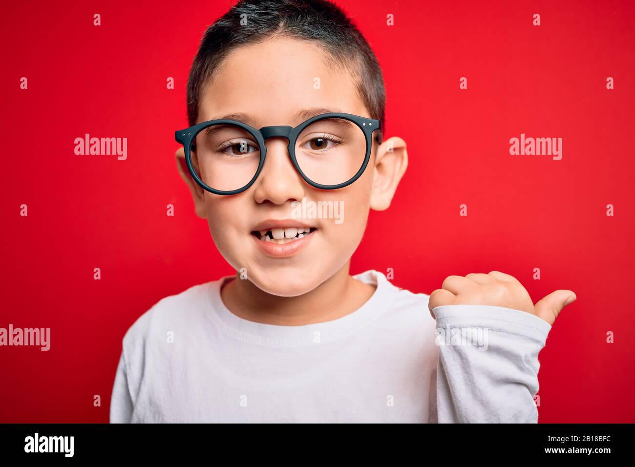 Young little smart boy kid wearing nerd glasses over red isolated ...