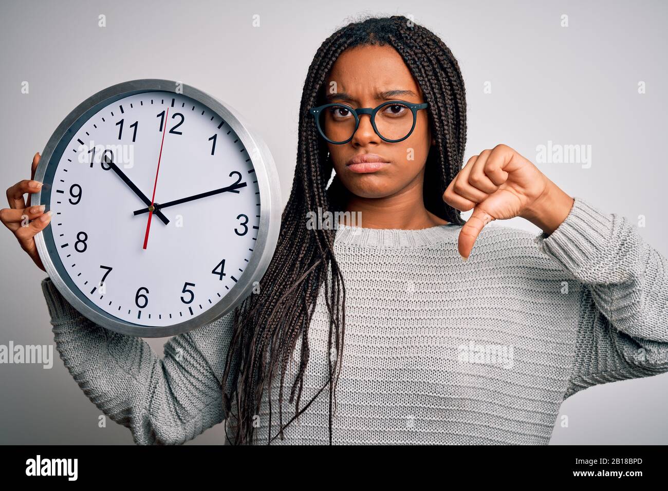 Young african american girl holding big minute clock over isolated ...
