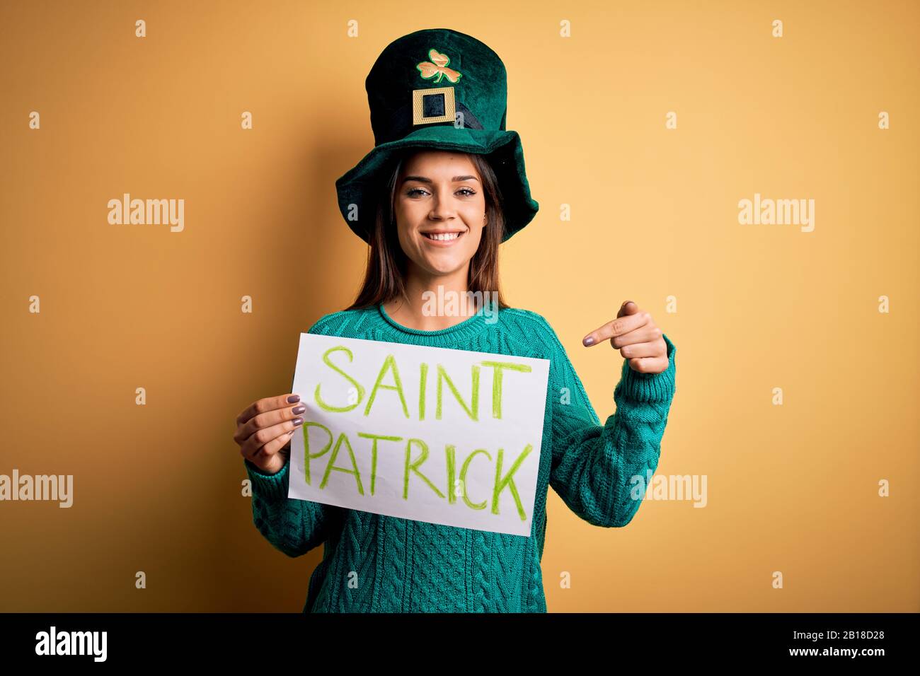 Woman wearing green hat celebrating st patricks day holding banner with ...