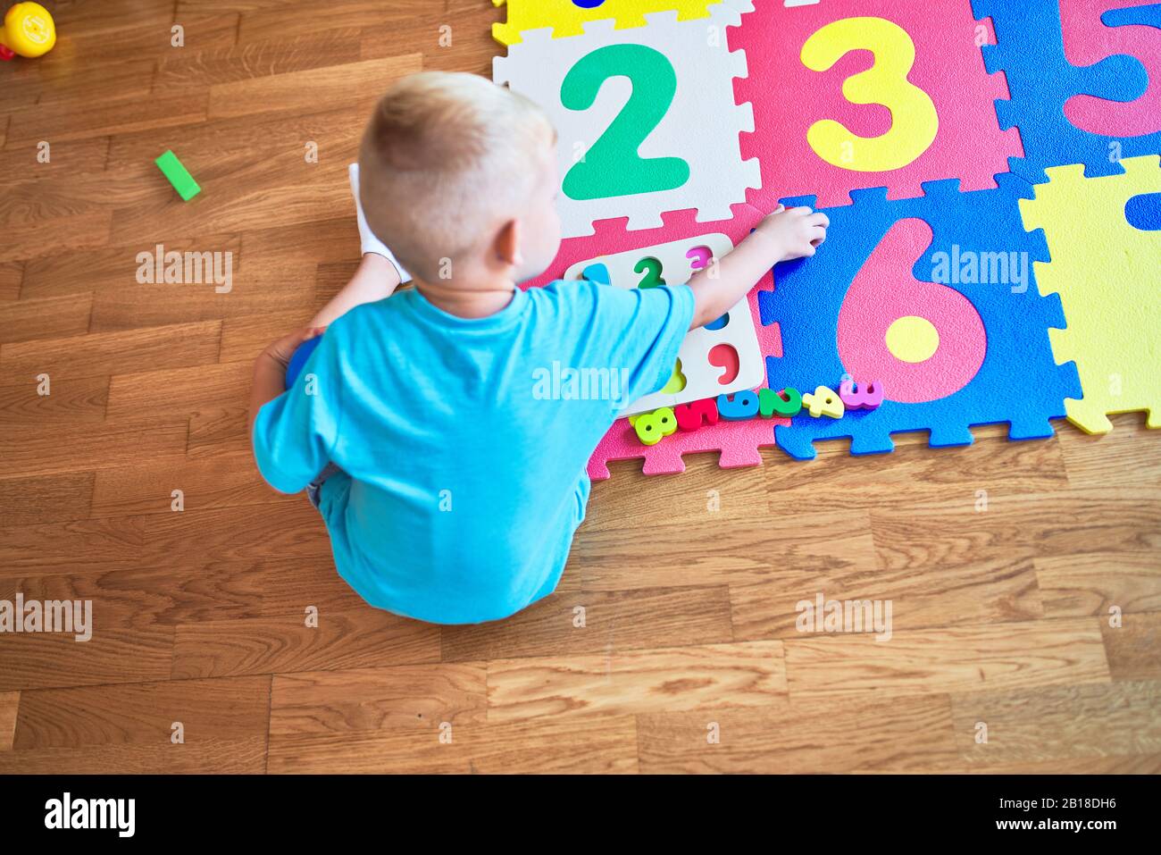 Young caucasian kid playing placing numbers at kindergarten ...