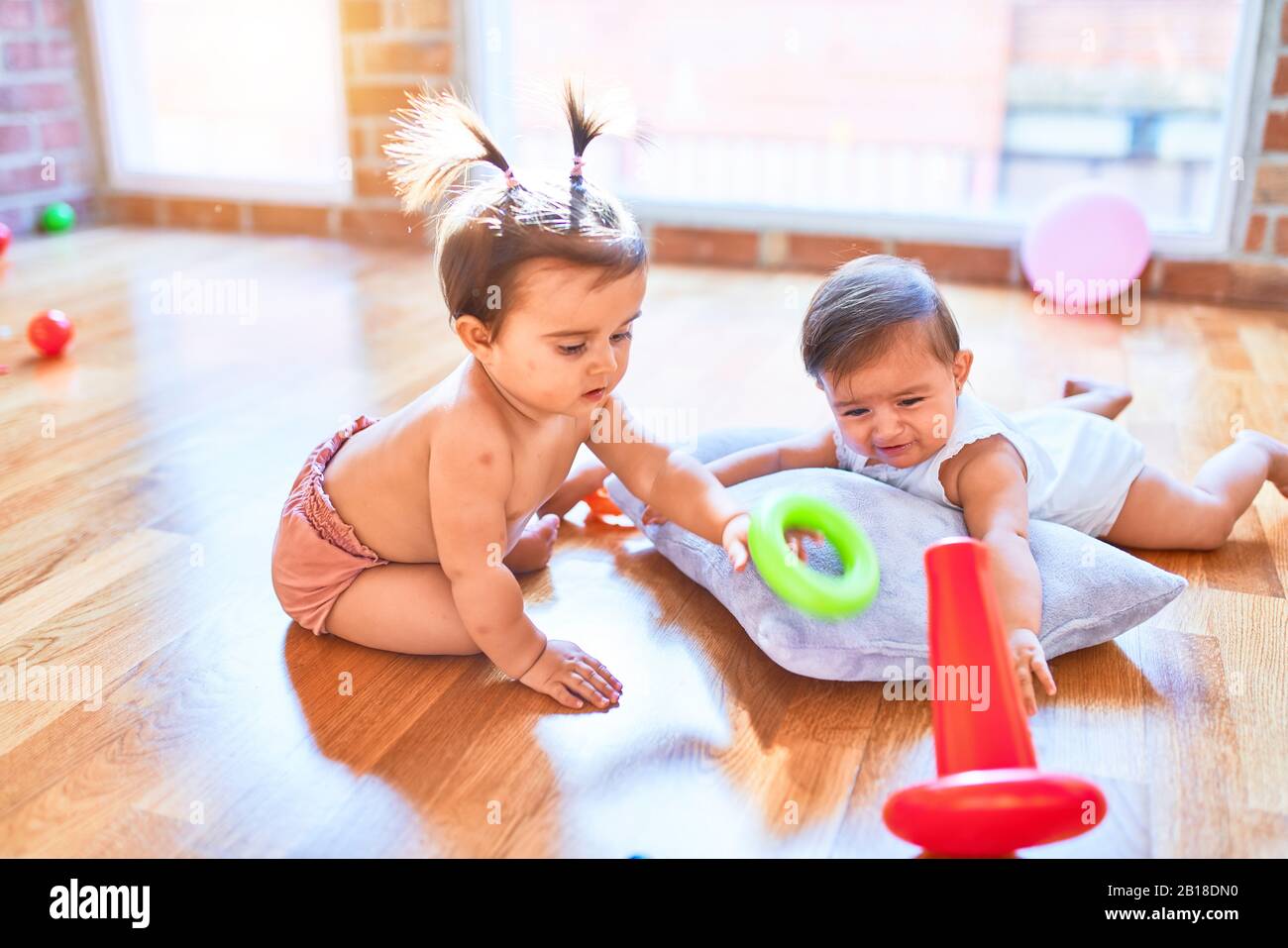 Beautiful infant happy girls playing together at home kindergarten ...