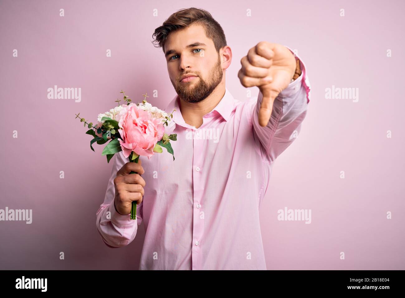 Young blond romantic man with beard and blue eyes holding beautiful ...