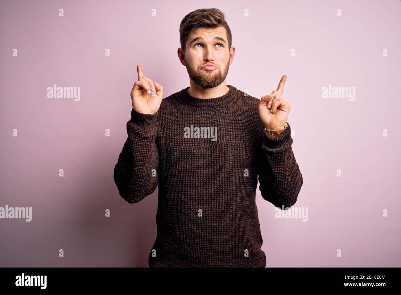 Young blond man with beard and blue eyes wearing casual sweater over ...