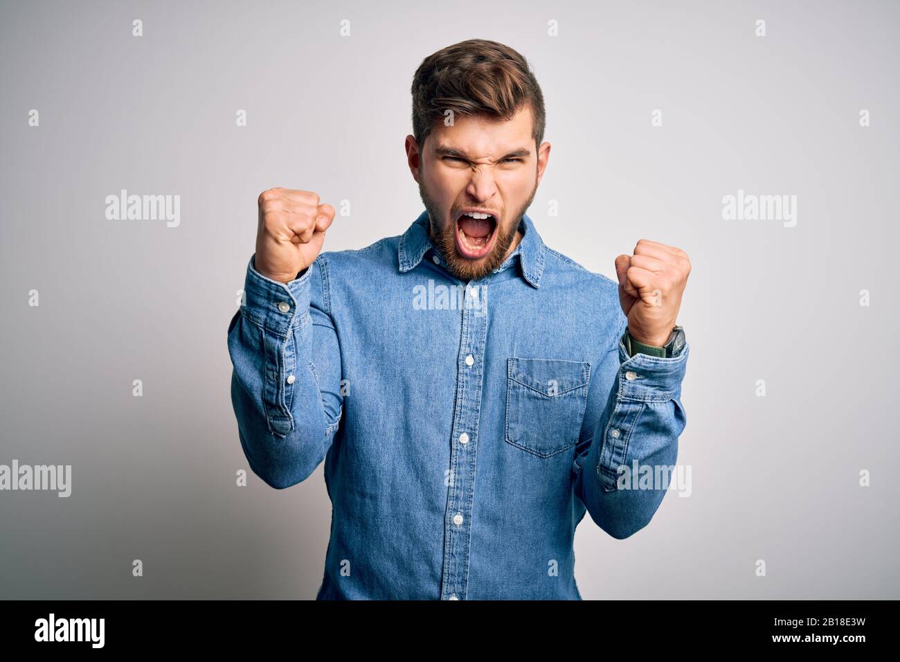 Young handsome blond man with beard and blue eyes wearing casual denim ...