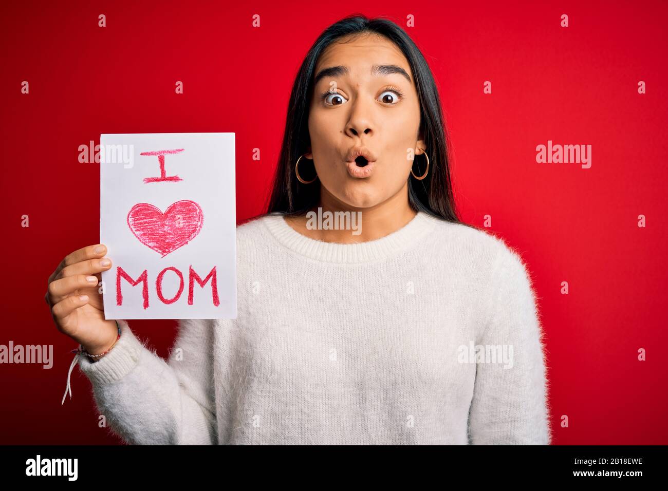 Young beautiful woman holding paper with love mom message celebrating ...