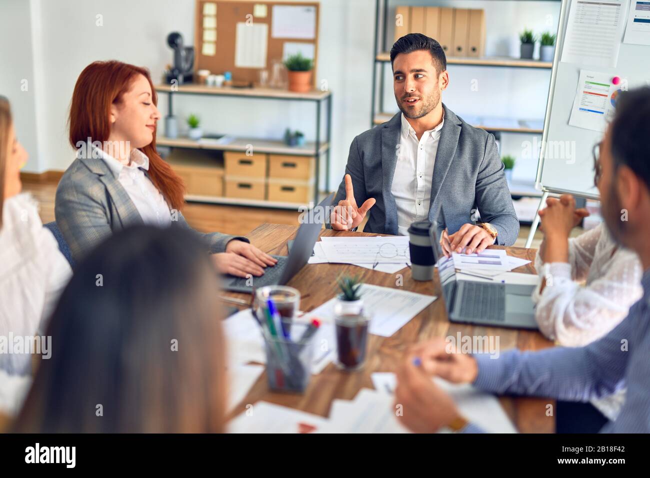 Group of business workers working together. Sitting on desk using ...