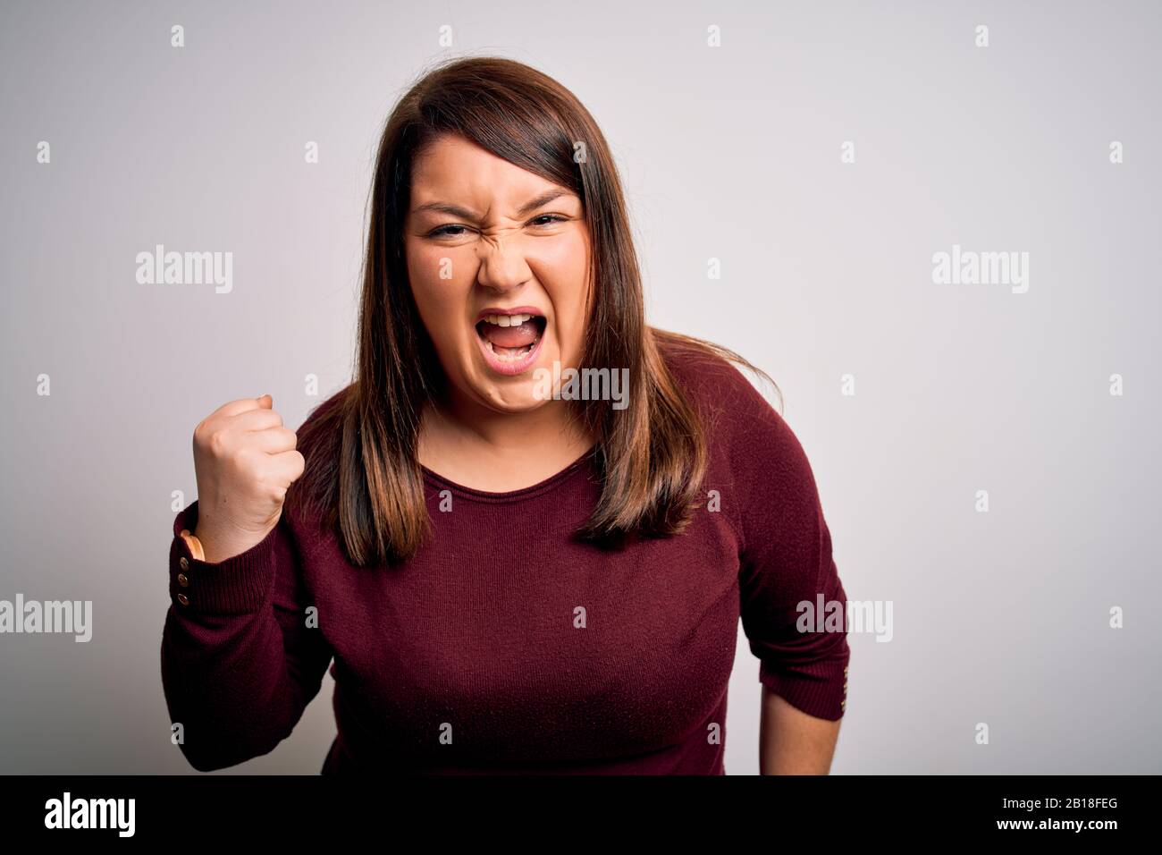 Beautiful brunette plus size woman wearing casual sweater over isolated ...