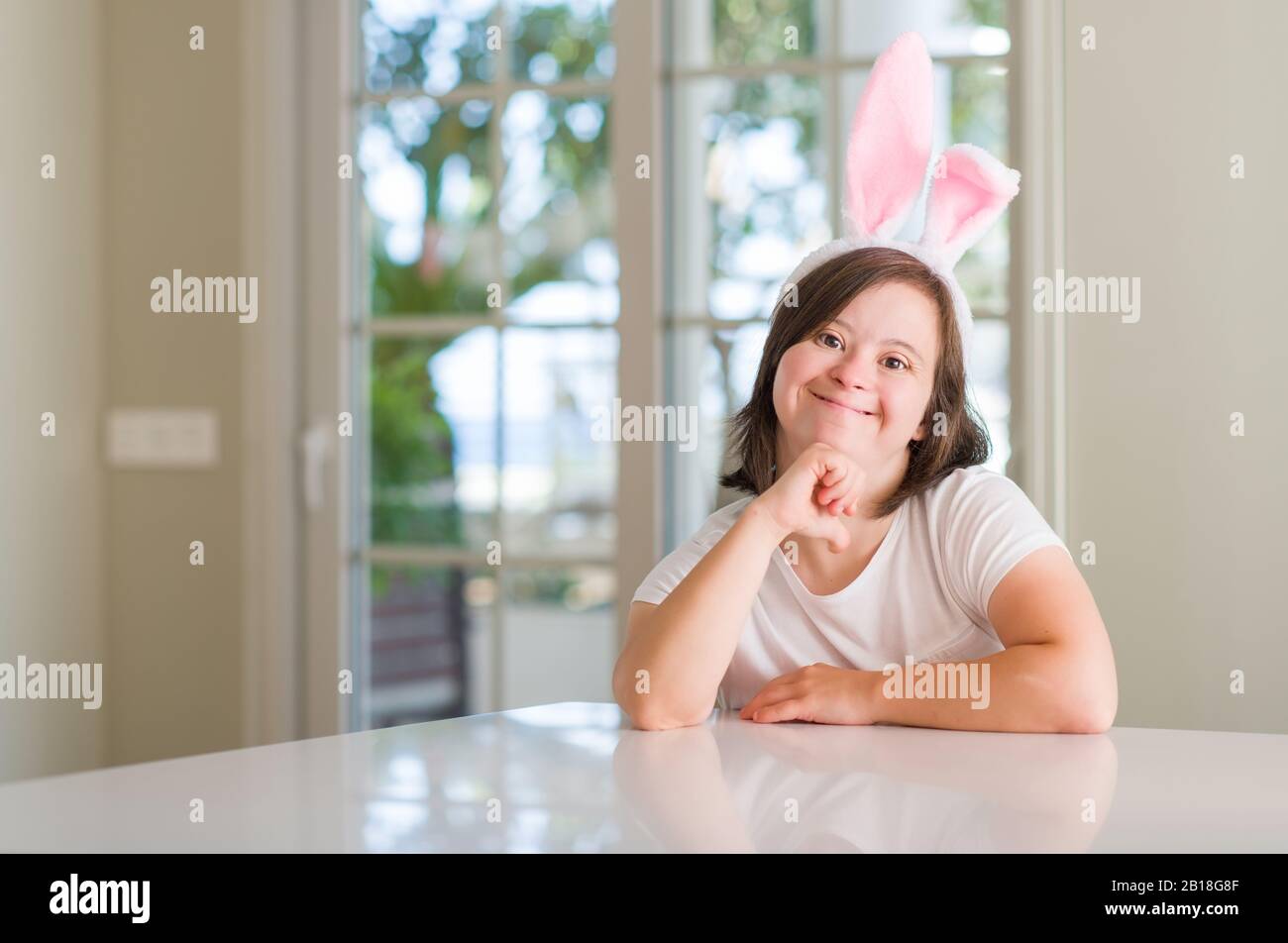 Down syndrome woman at home wearing easter rabbit ears with surprise ...