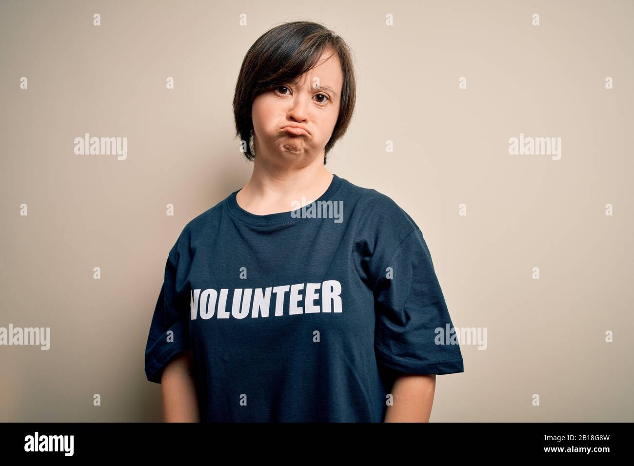 Young down syndrome volunteer woman wearing social care charity t-shirt ...