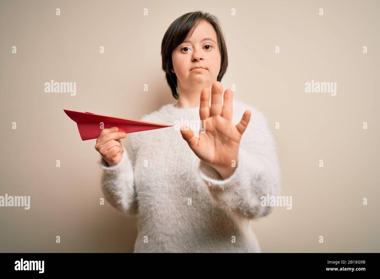 Young down syndrome woman having fun with paper plane as dream of ...