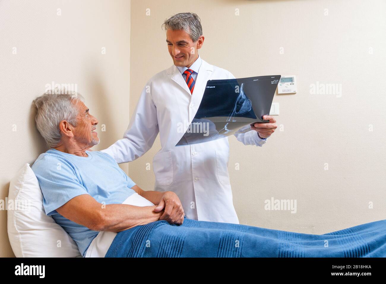 Male doctor showing x-ray scan test to patient in hospital Stock Photo ...
