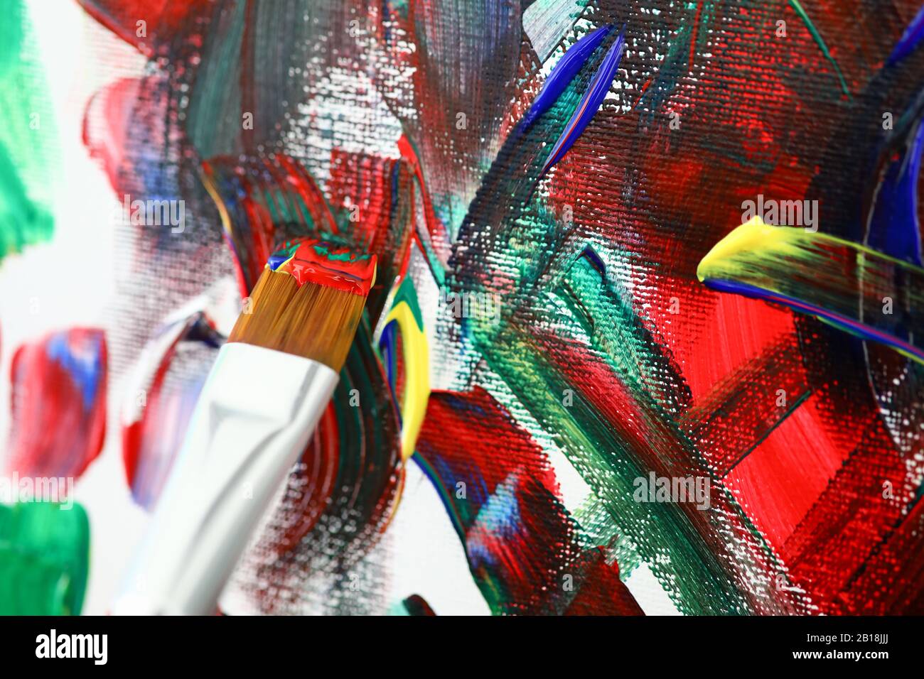 Brush with acrylic paint on background of art canvas Stock Photo - Alamy