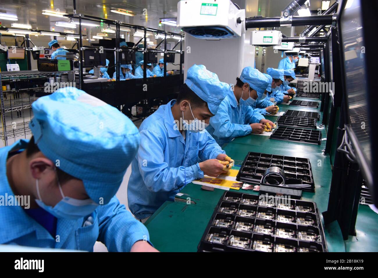 Beijing, China. 24th Feb, 2020. Staff wearing masks work at the factory ...