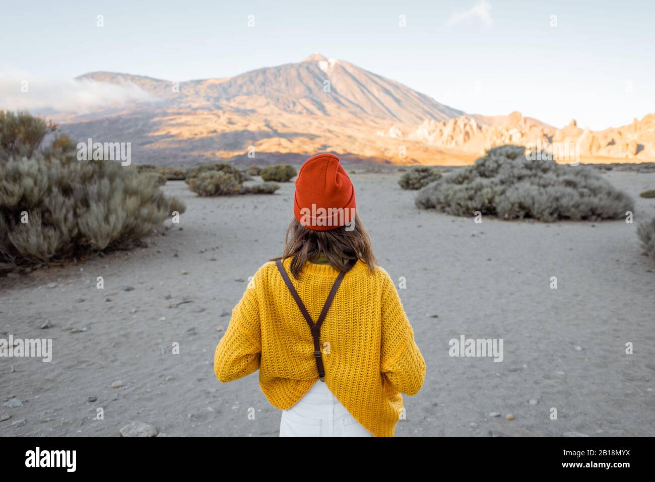 Stylish woman in bright clothes on the beautiful volcanic valley with ...