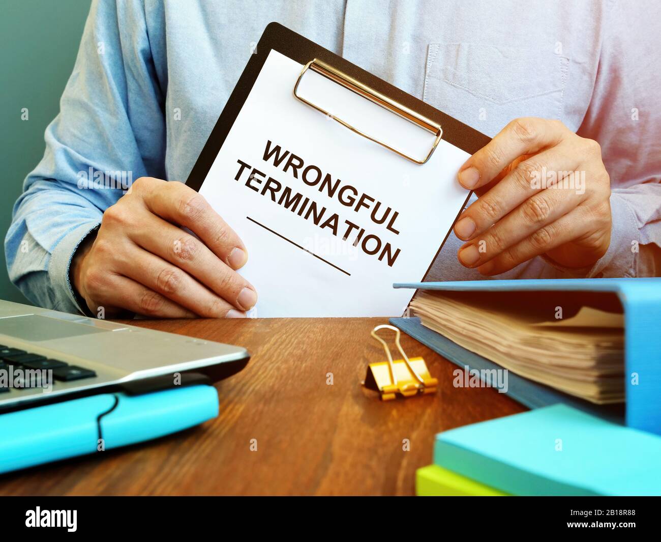 Employee holds papers about wrongful termination Stock Photo - Alamy