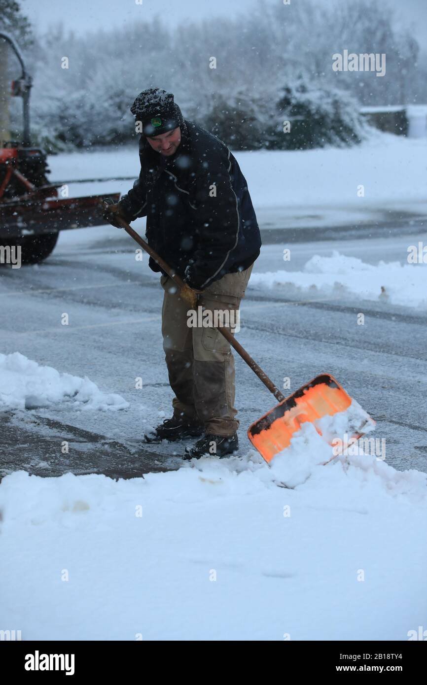 A man clears snow at Bedale Golf Club, North Yorkshire after overnight ...