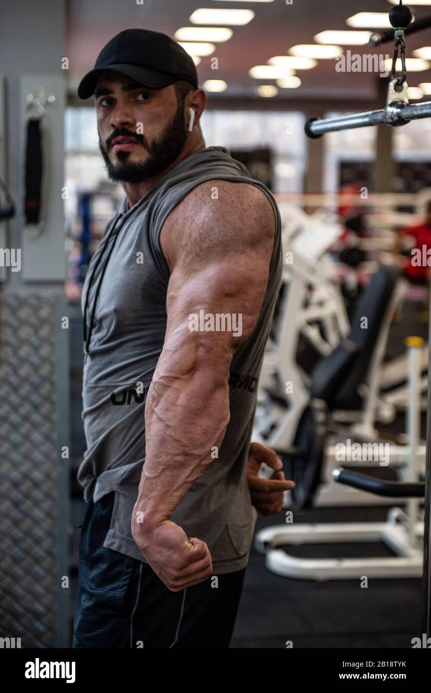 strong powerful athlete man with beard showing his triceps muscle in ...