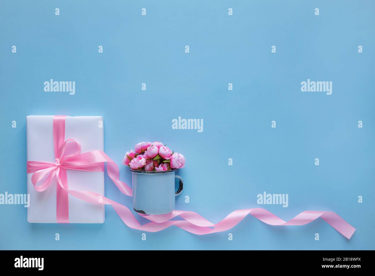 Gift box wrapped in white paper with pink ribbon Stock Photo - Alamy