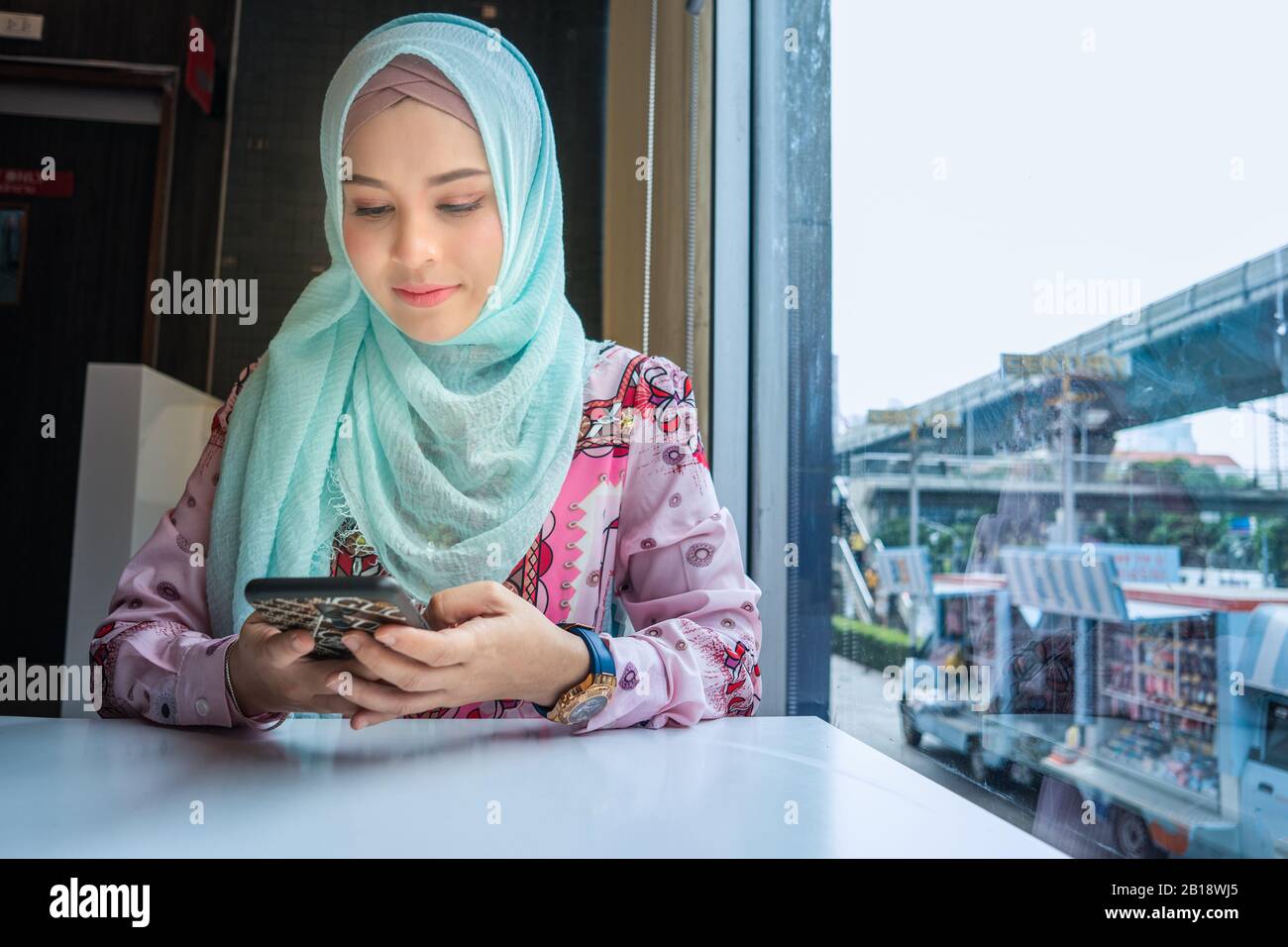 beautiful Islamic girls use mobile phones while waiting for meal Stock ...