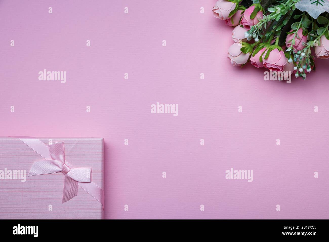 Gift box with pink bouquet of roses on powder pink paper background ...