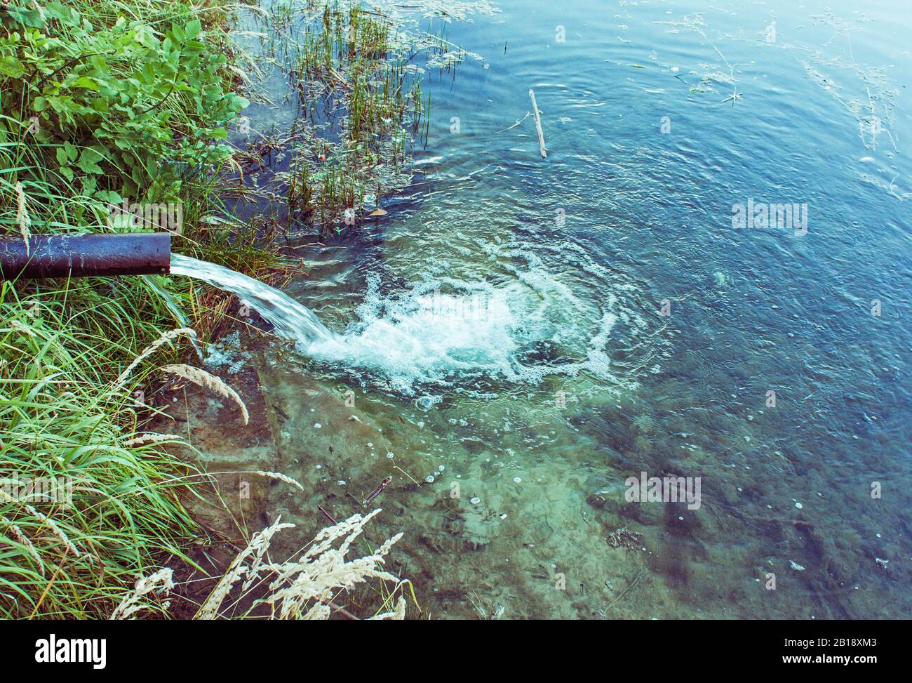 Sewage flows into the lake, river. Water flows from the pipes ...