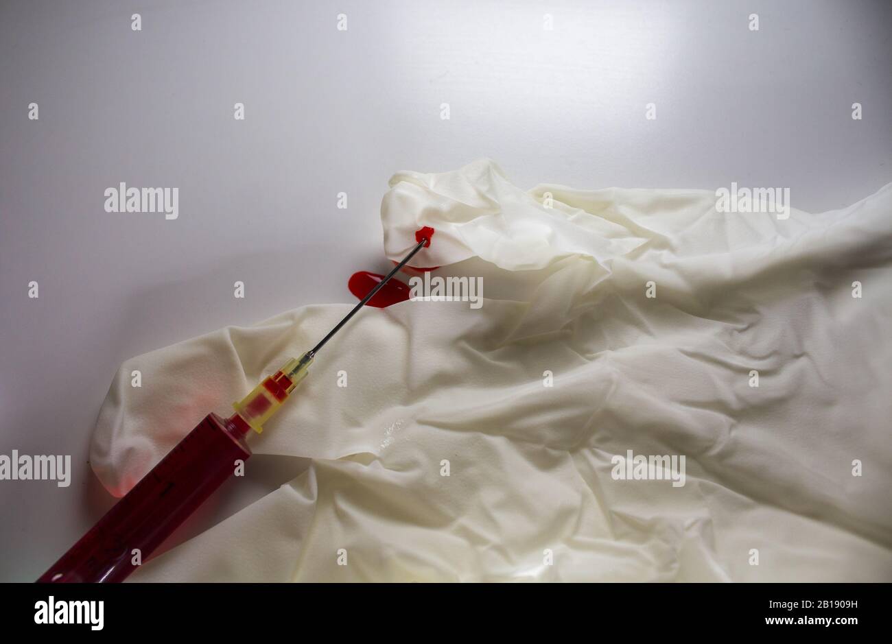 Close-up of a syringe with injection needle and artificial blood on ...
