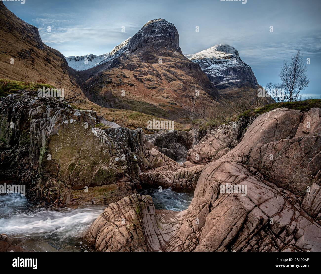 The River Coe flowing through Glen Coe in winter with the group of ...