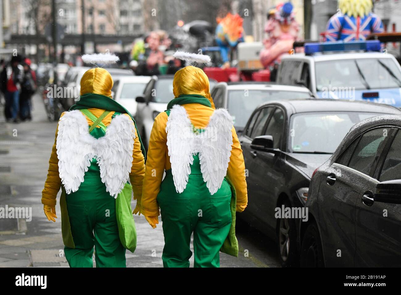 Duesseldorf, Germany. 24th Feb, 2020. Two Jecken with angel wings come ...