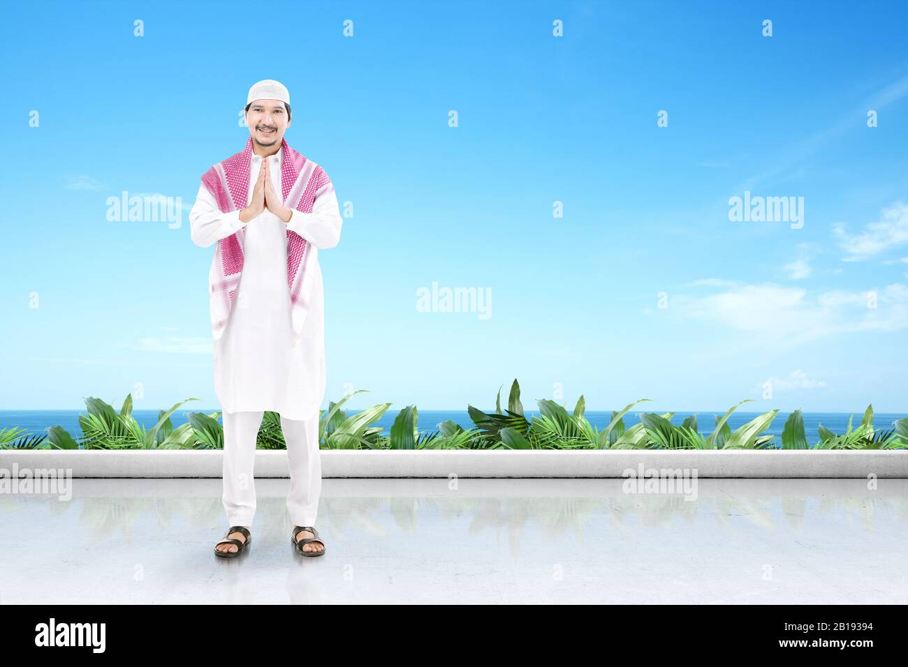 Asian Muslim man standing while raised hands and praying on the mosque ...