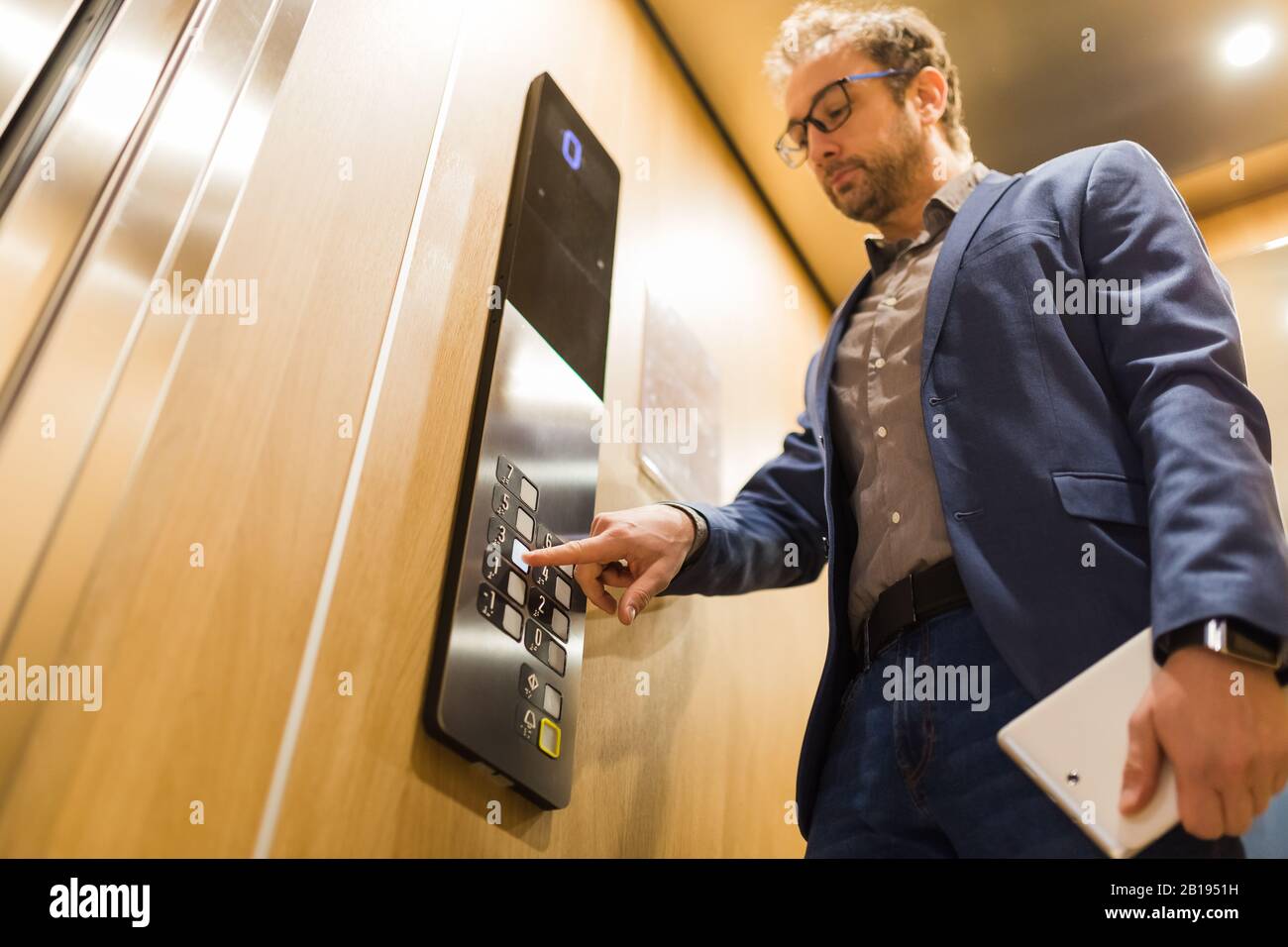 Close up of businessman pressing third floor control panel button in ...