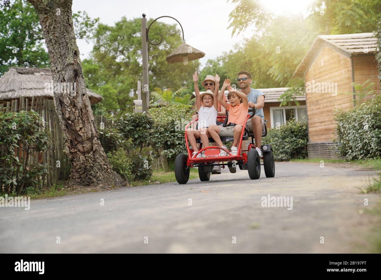 Parents with kids having fun riding kart Stock Photo - Alamy