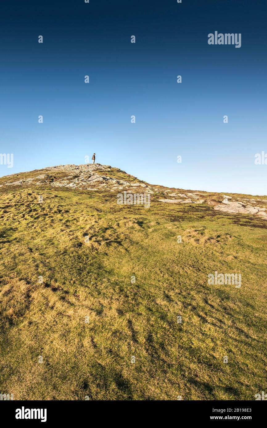 A man standing on the rugged summit of Trevelgue Head on the coast of ...