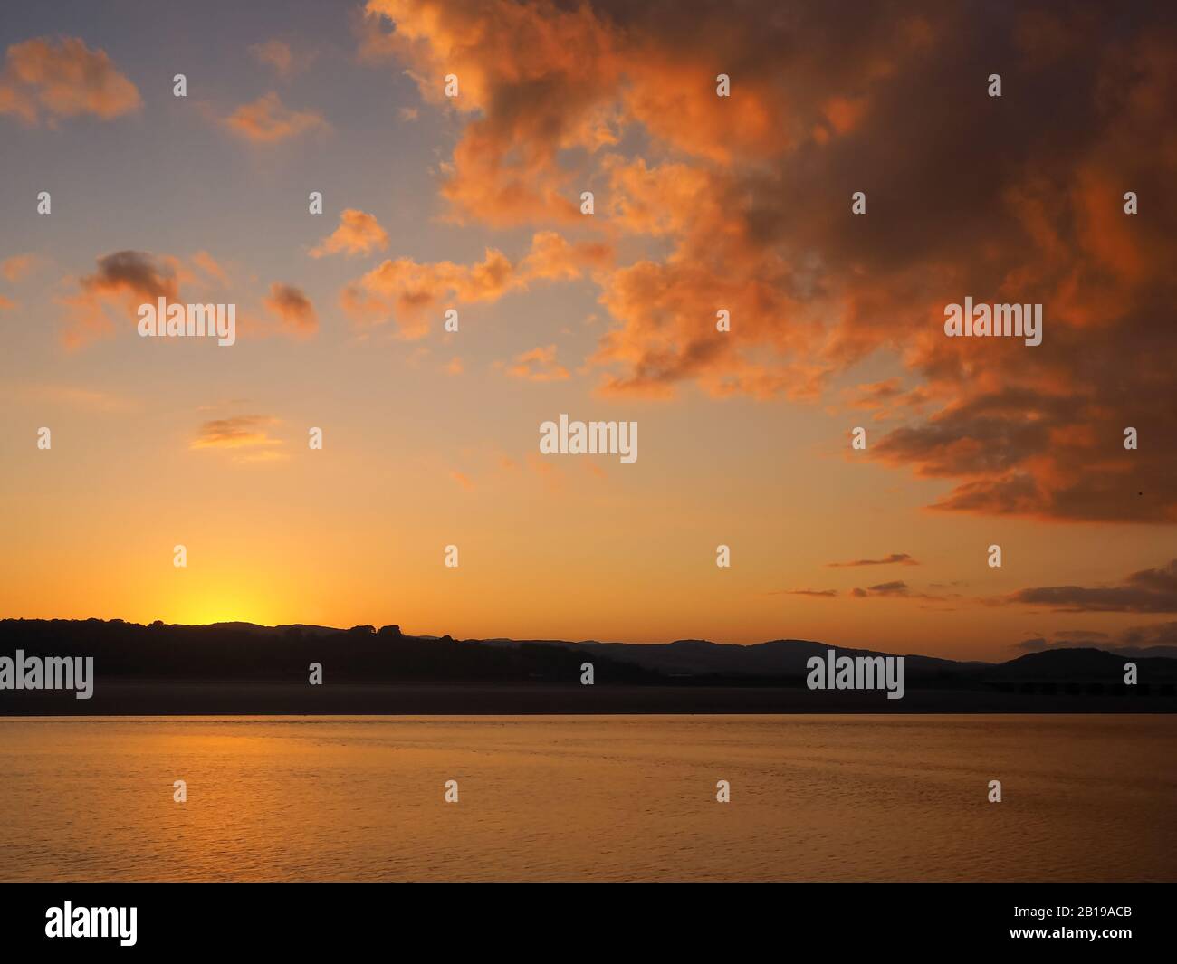 Beautiful glowing sunset sky and dramatic clouds over the Kent Estuary ...