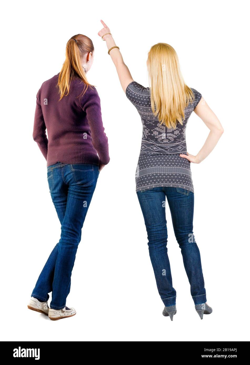 Back view of two pointing girl in sweater. Rear view people collection ...