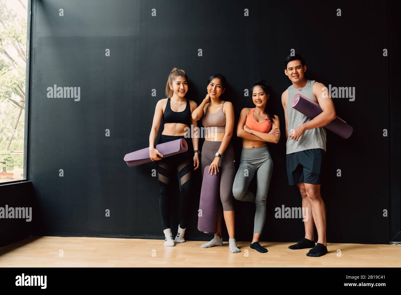 Happy smiling man and women looking at camera altogether in gym. Group ...