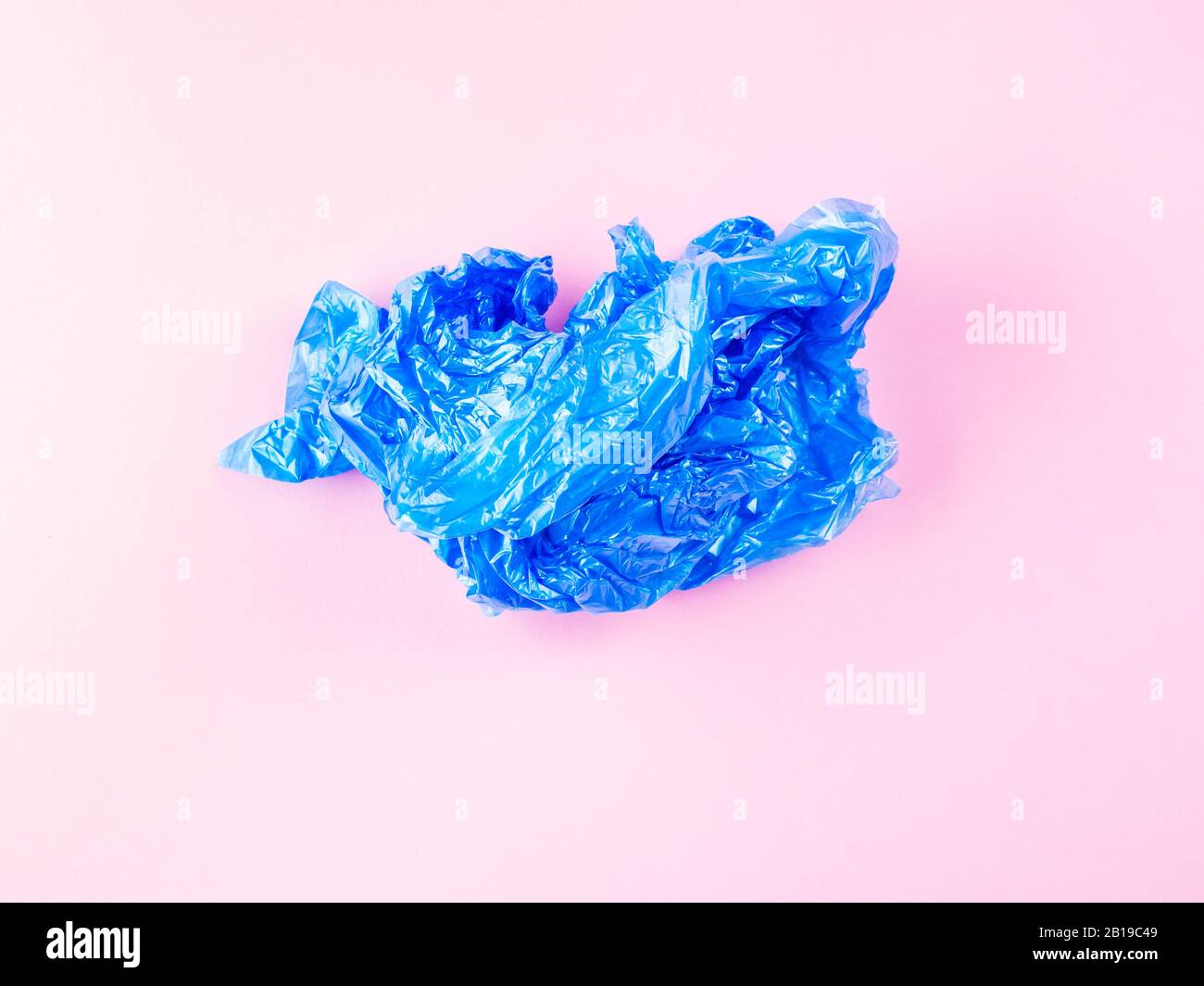 Crumpled blue plastic trash bag on pink background Stock Photo - Alamy