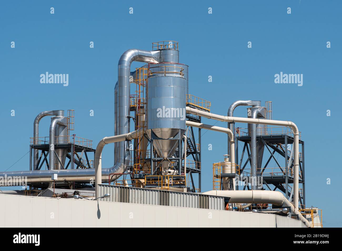 Pipes and Chimney of a wood board factory on blue sky. Copy space Stock ...