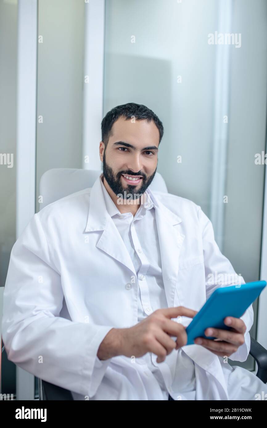 Male doctor sitting on chair hi-res stock photography and images - Alamy