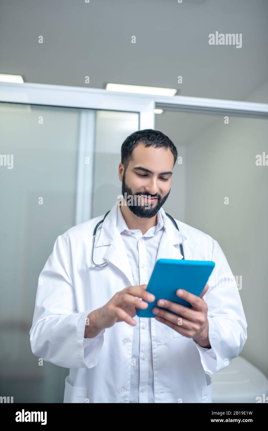 Male doctor in a white robe searching web Stock Photo - Alamy