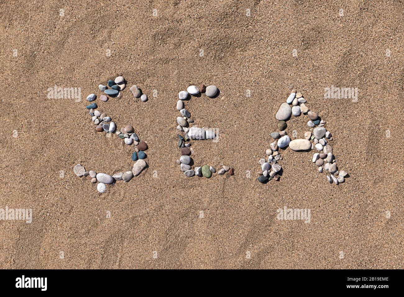 The word SEA created with color sea pebbles the sand Stock Photo - Alamy