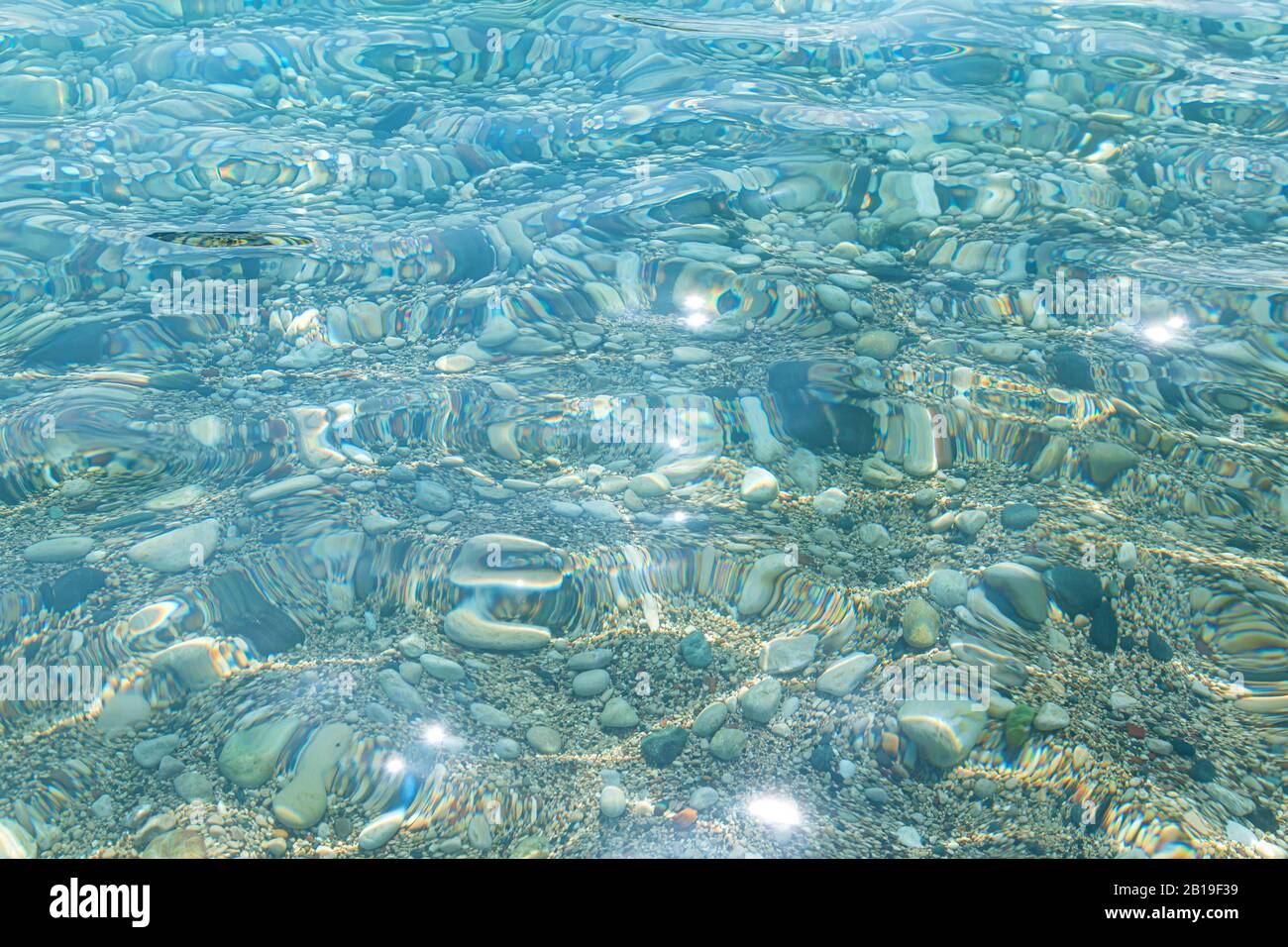 Clear water surface with rainbow highlights. Sea background Stock Photo ...
